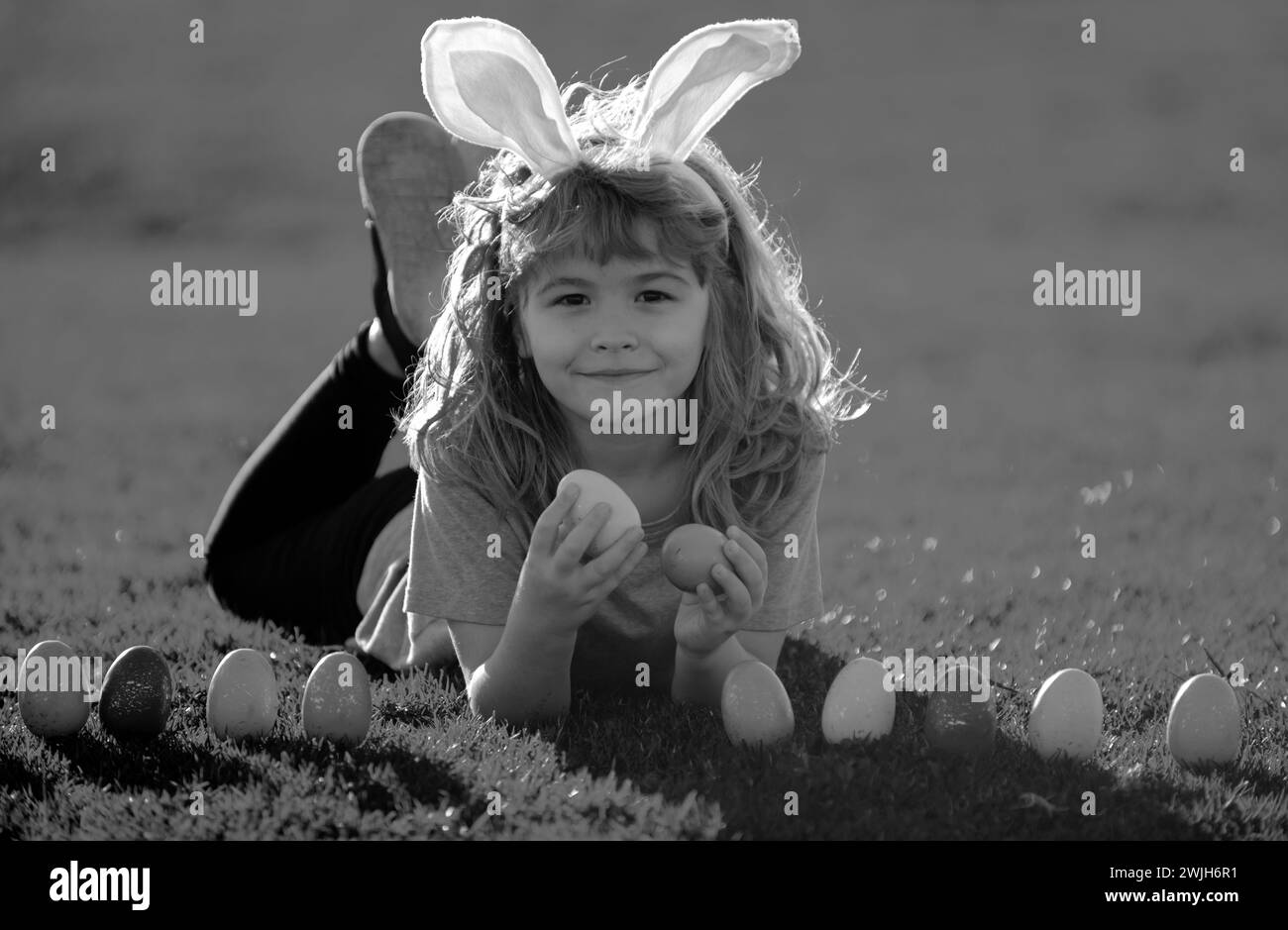 Child boy with easter eggs and bunny ears on grass. Child boy hunting ...
