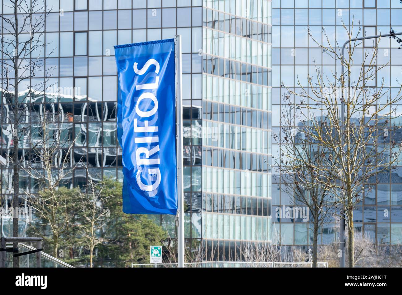 building with flags GRIFOLS in blue, global healthcare company develops plasma-derived medicines ...