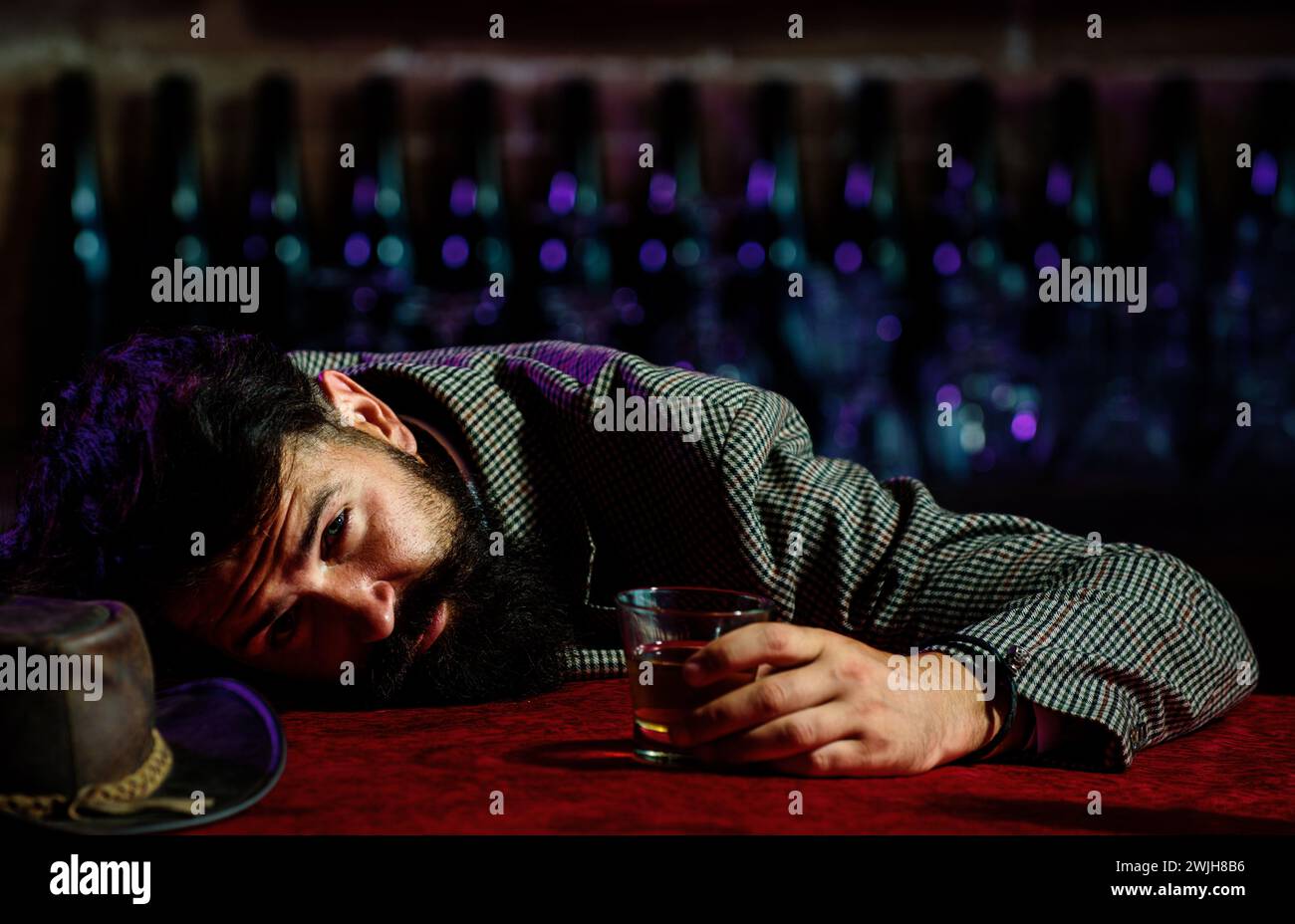 Upset bearded man drinker alcoholic sitting at bar counter with glass ...