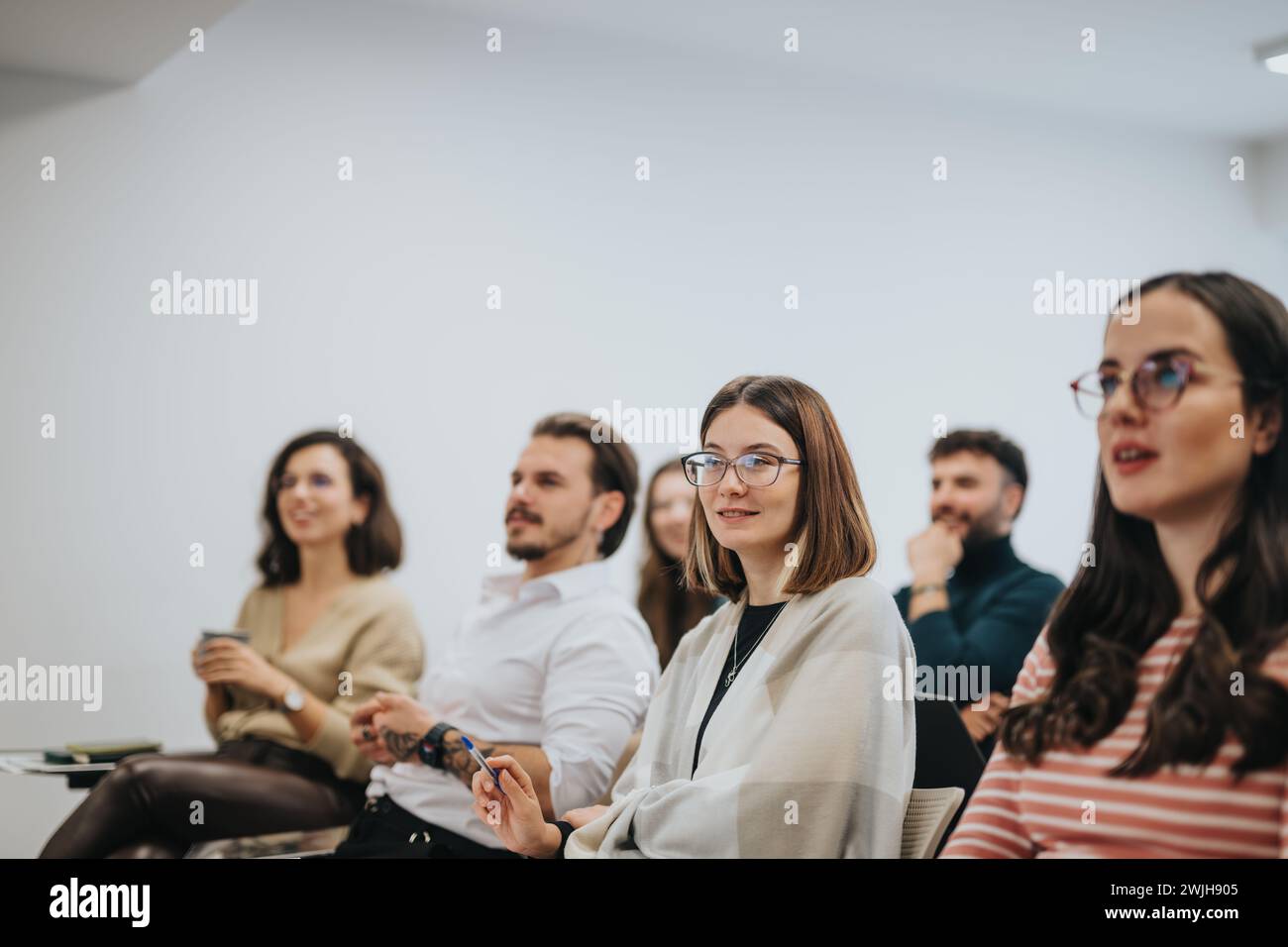 Group of attentive employees listening to a speaker at a seminar. A ...