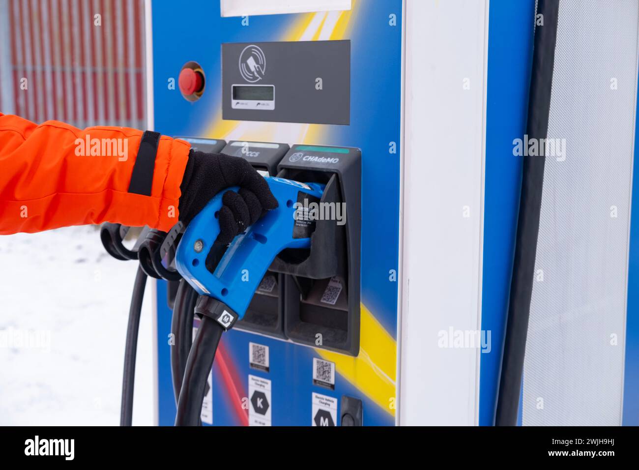 man holding DC, hpc charging connector in hand, electric vehicle CCS2 ...