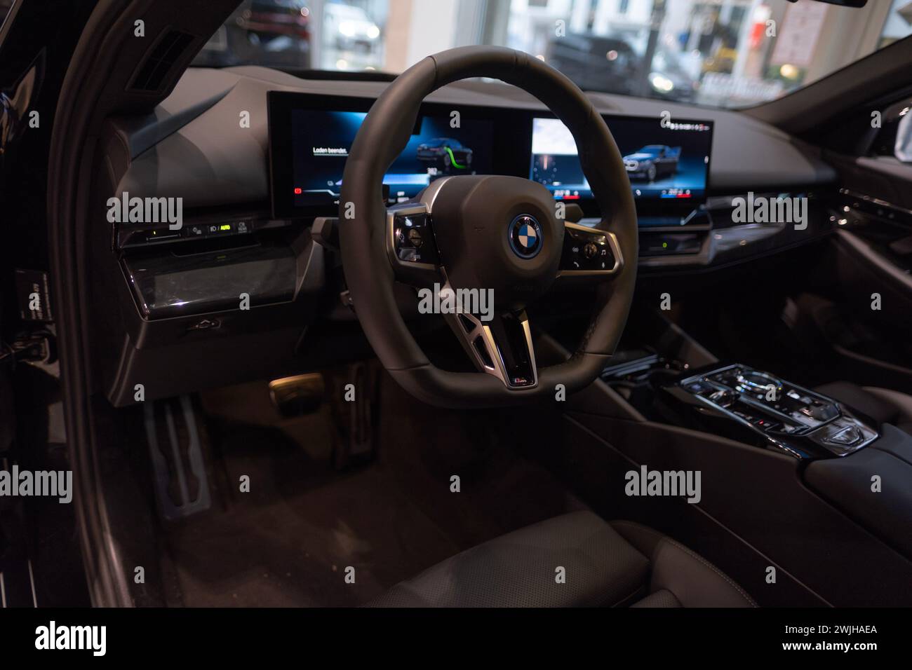 Interior, cockpit of BMW i5 eDrive40 car, digital panel, instruments on steering wheel, EV ...