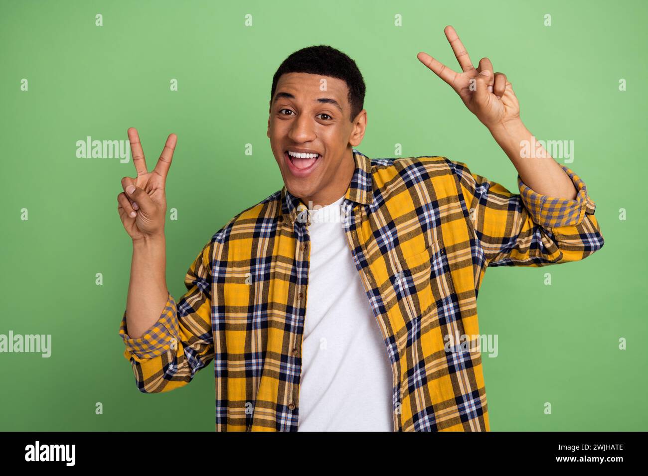 Portrait of young optimistic man wearing yellow shirt posing with ...