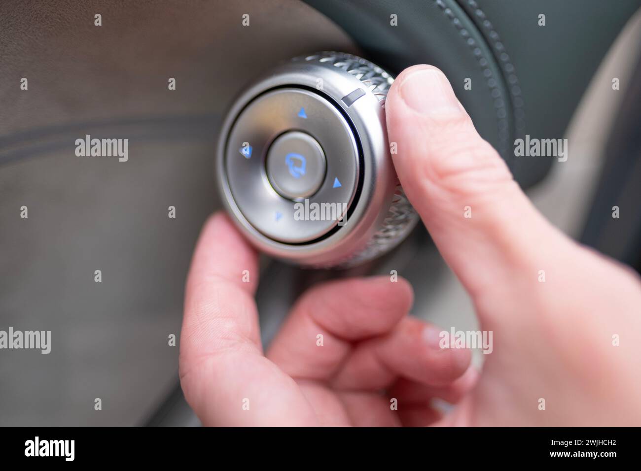 close-up sound system controls on driver's door, Genesis GV60 Electric Car, male hand turns ...