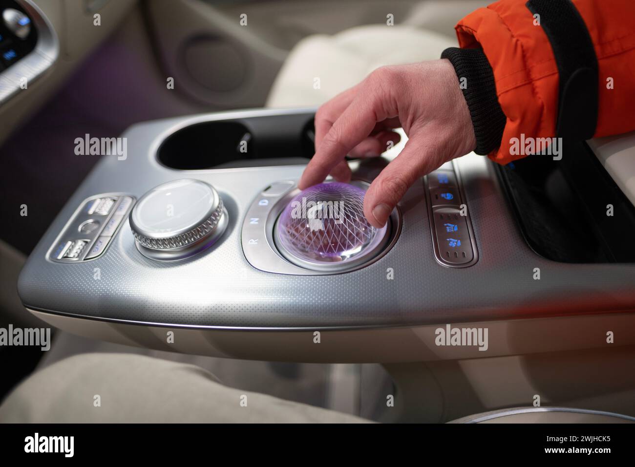 man in car driving Genesis GV60 Electric Car, male hand on button ...