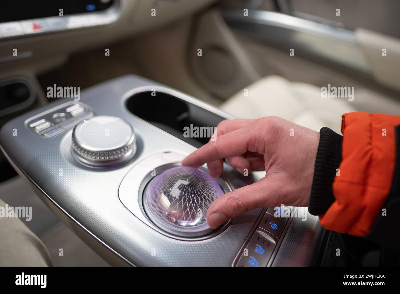 man in car driving Genesis GV60 Electric Car, male hand on button ...