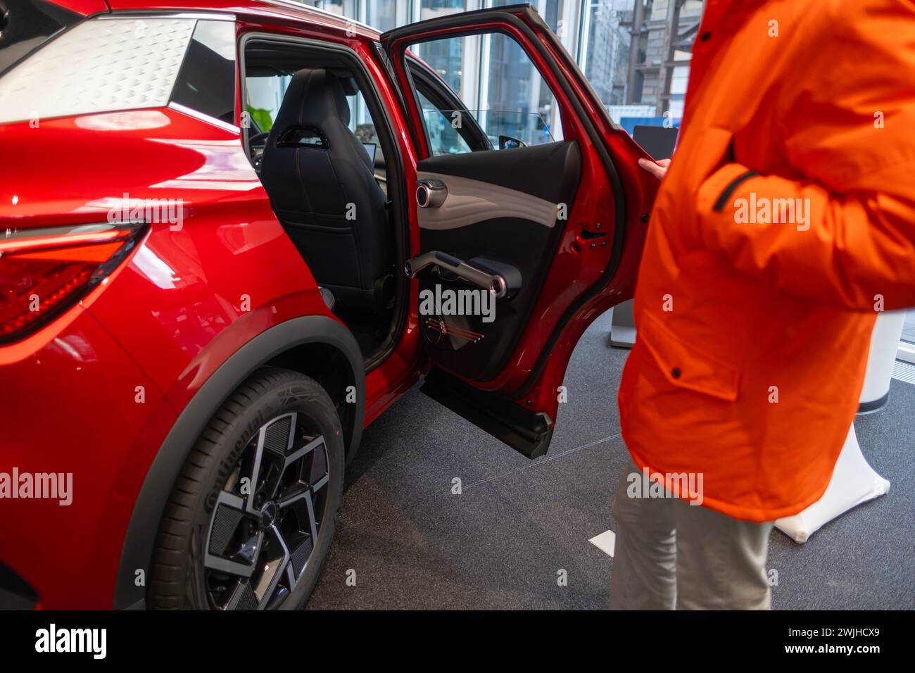young man examines, chooses new red BYD ATTO 3 Car in Studio, test ...