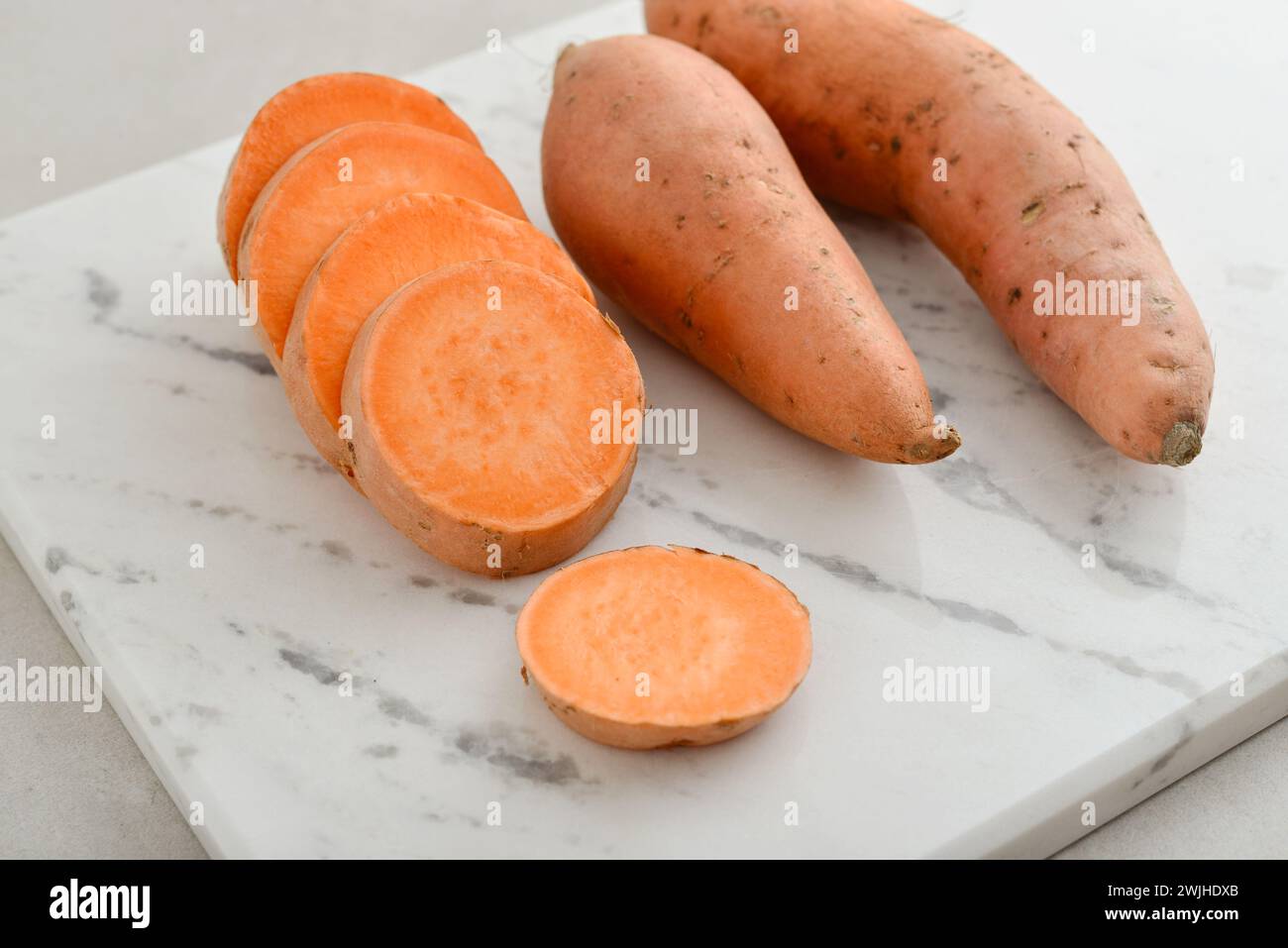 Set of fresh whole and sliced sweet potatoes on light background Stock ...