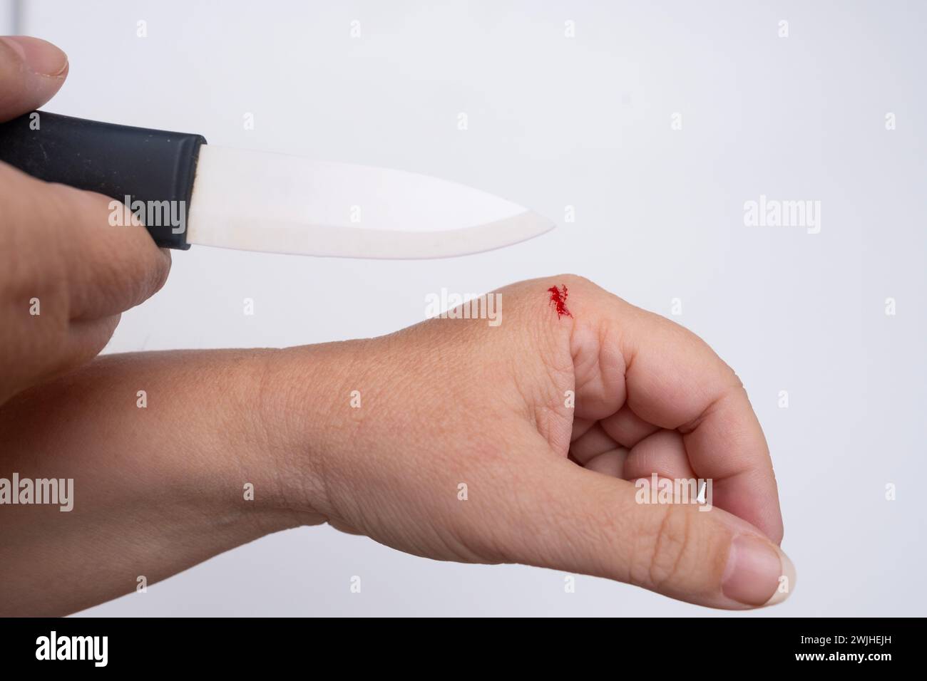 drop of red blood, close-up of female hand, wound from cut, kitchen ...