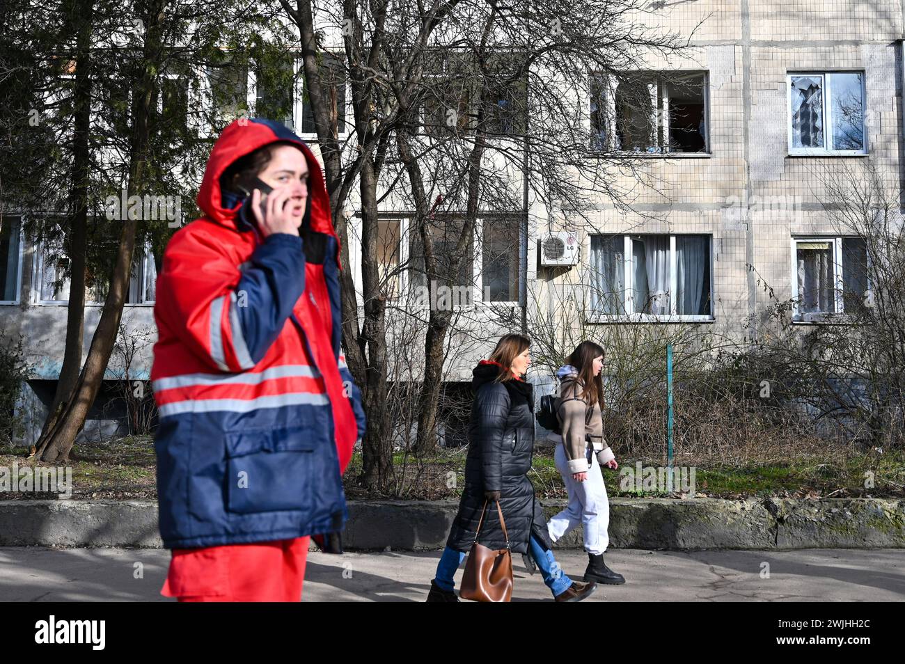 Non Exclusive: A paramedic talks on the phone as two women walk past an ...