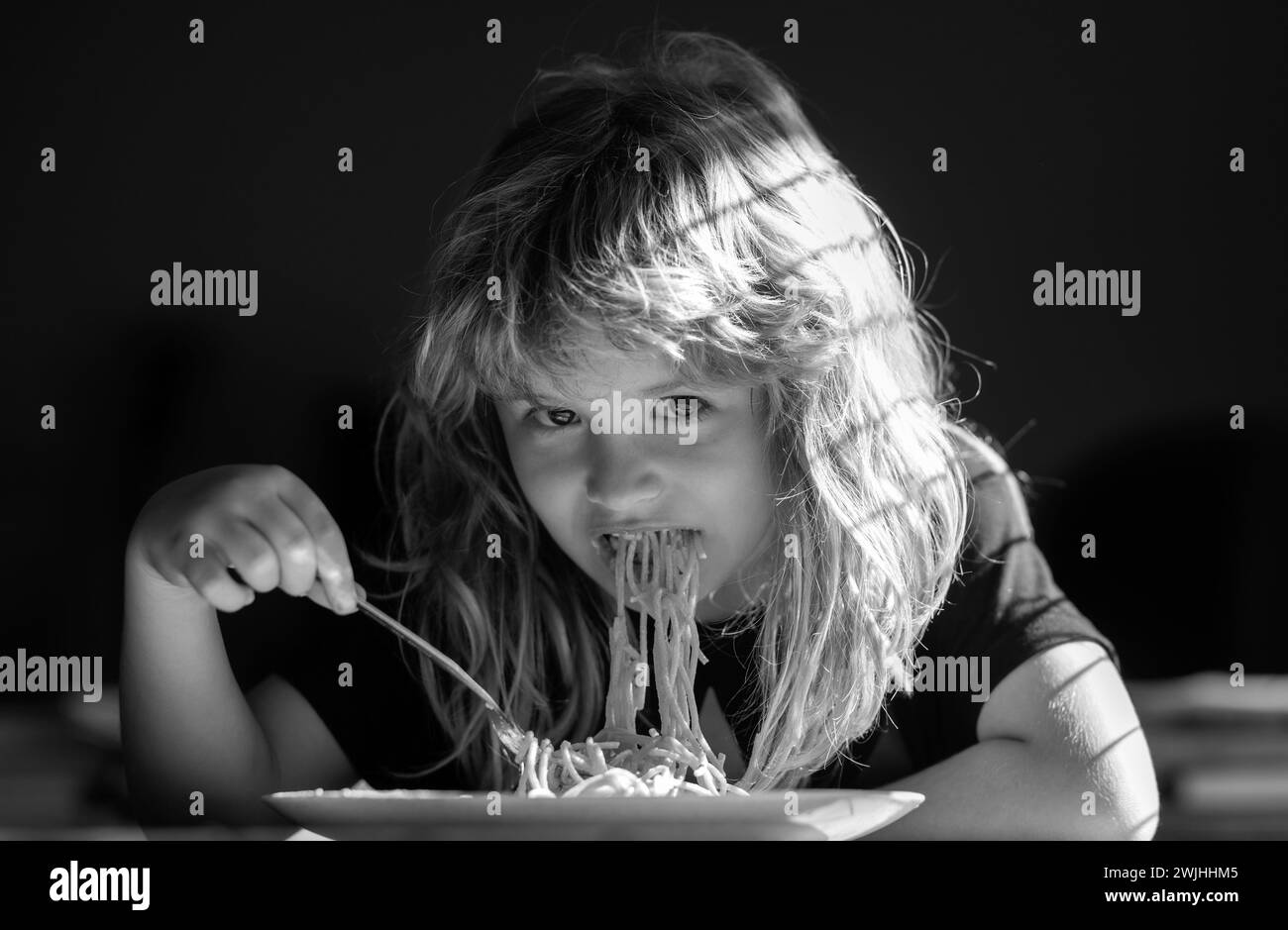 Cute child eating breakfast at home. Cute little kid eating spaghetti ...