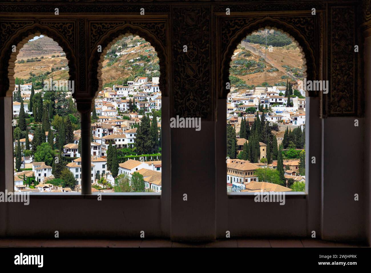 View of the city through three arabesque arched windows, Nasrid Palaces, Alhambra, Granada ...