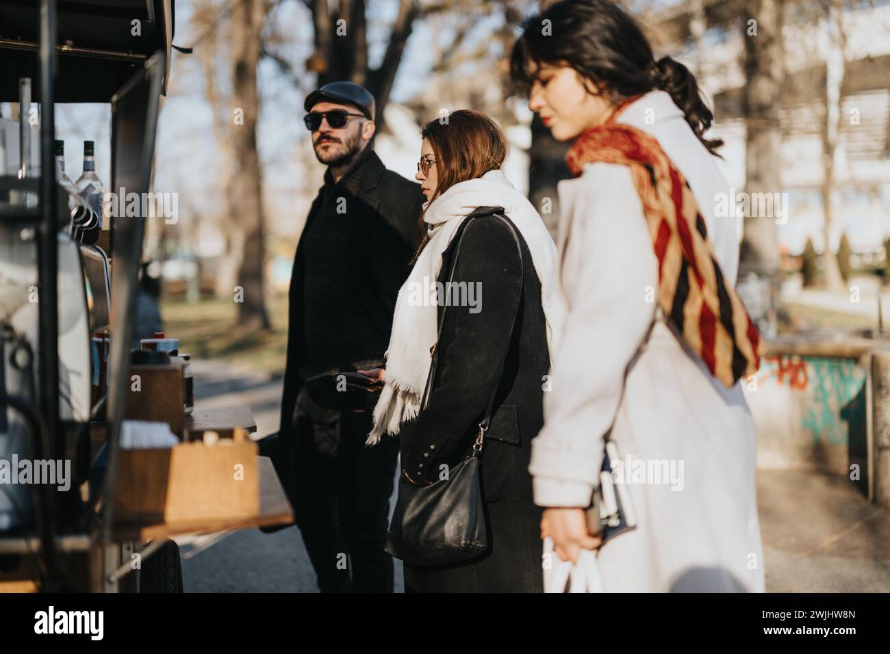 A group of trendy friends waiting in line at an outdoor street food ...