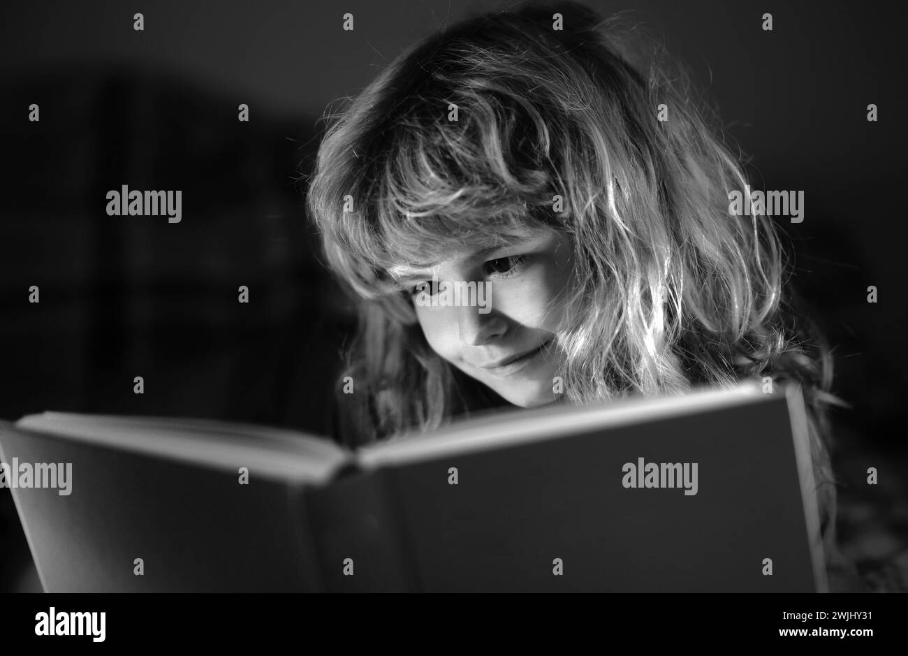 Child read fairy tale from book. A little cute boy reading a book lying ...