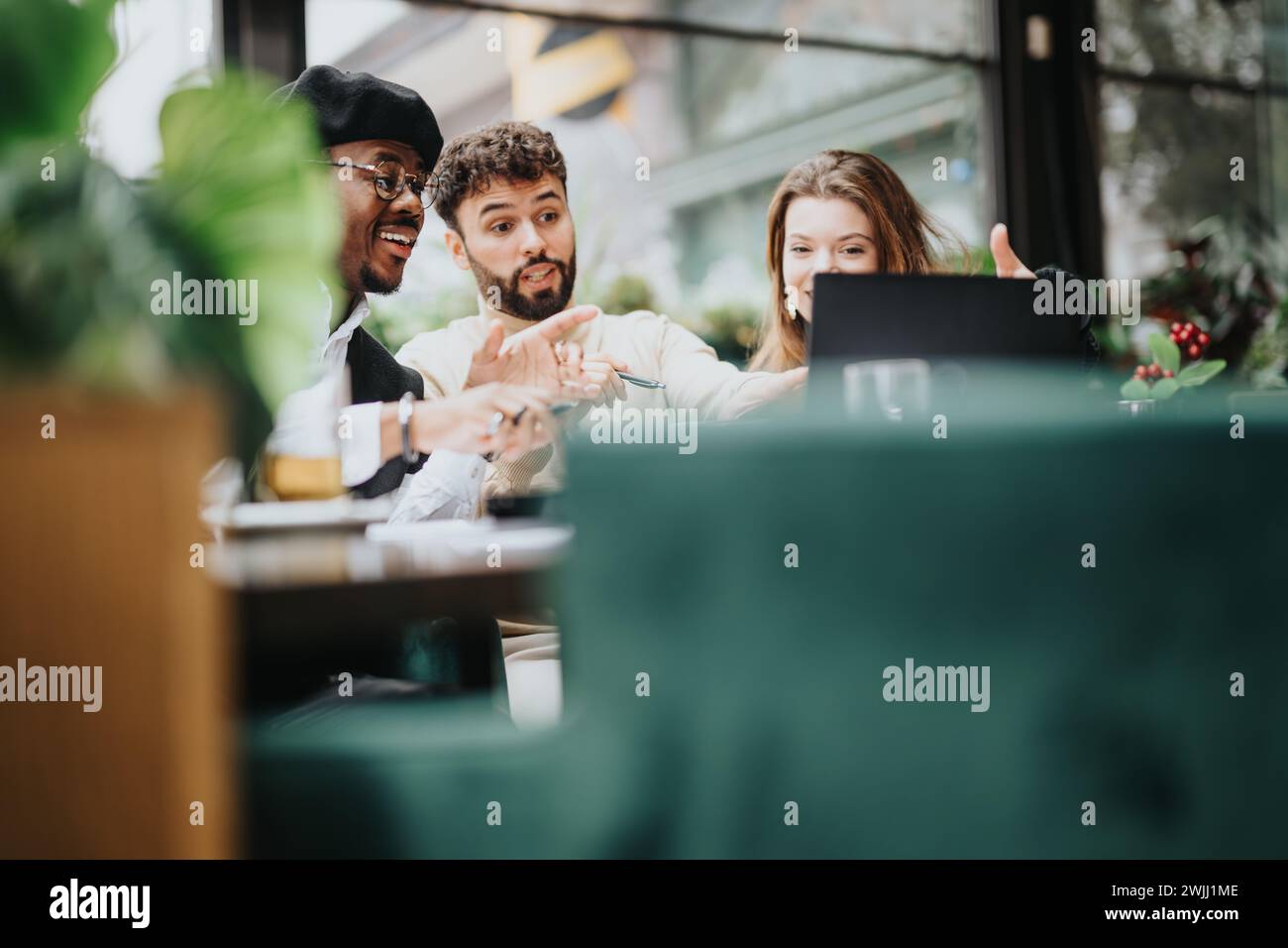 Three multiethnic colleagues collaborating over paperwork in a relaxed ...