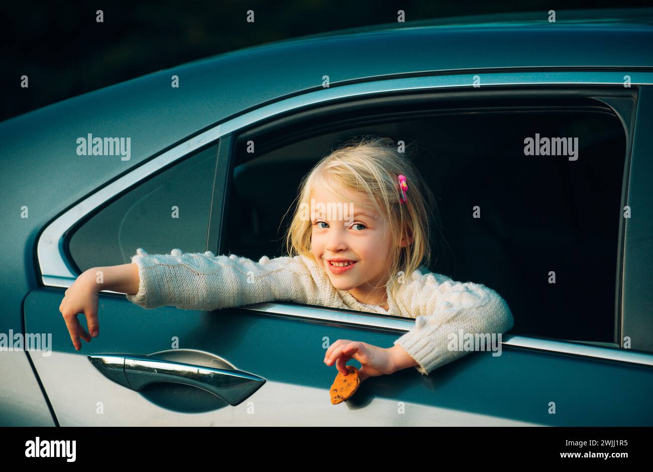 Sweet female child looking trough car window. Cute pensive girl looking ...