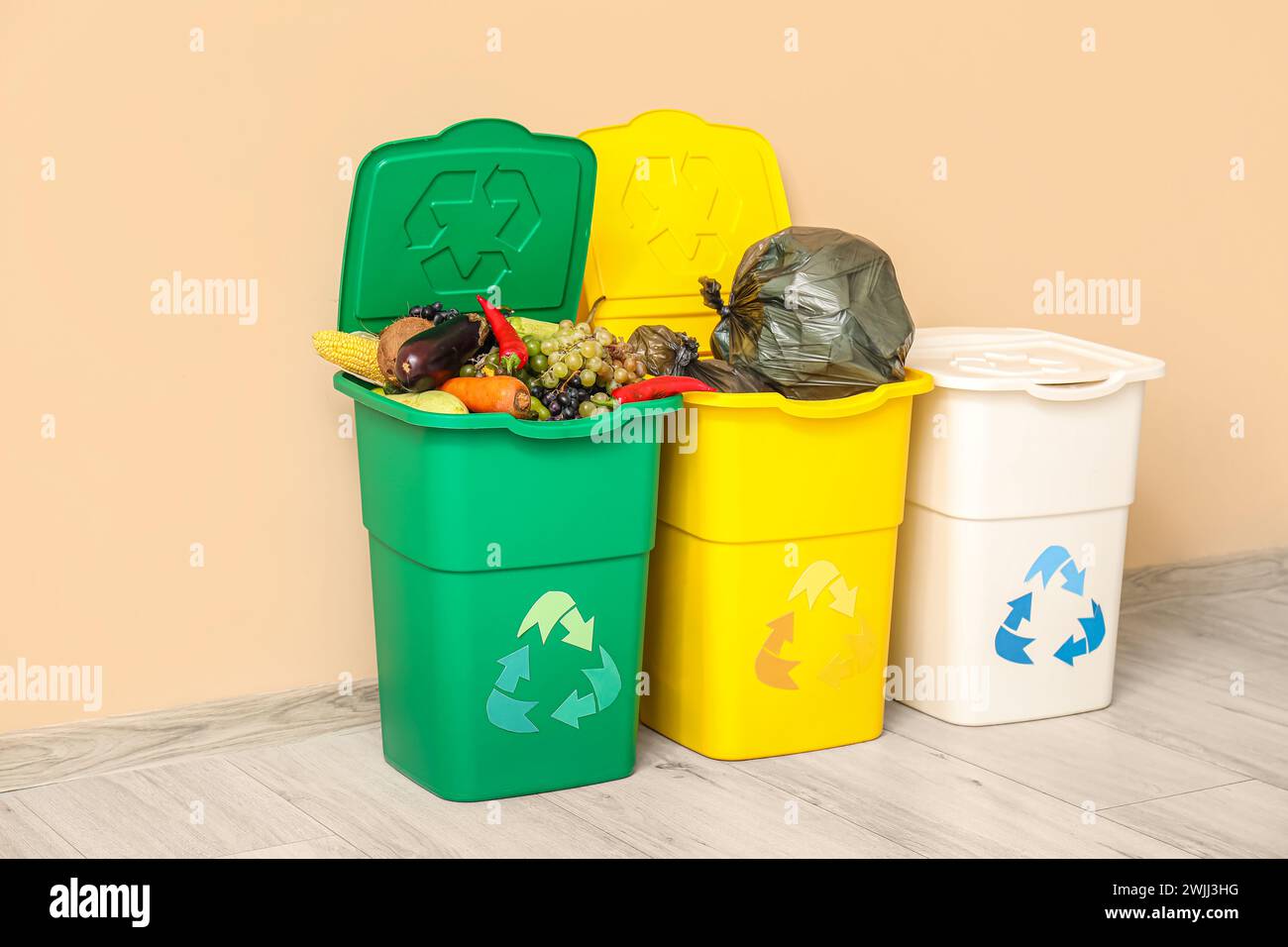 Containers for trash with food waste and full garbage bag near beige ...