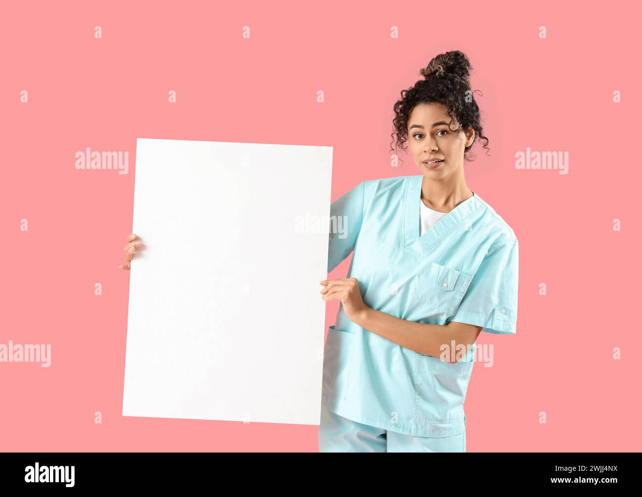 Female African-American medical intern with blank poster on pink ...