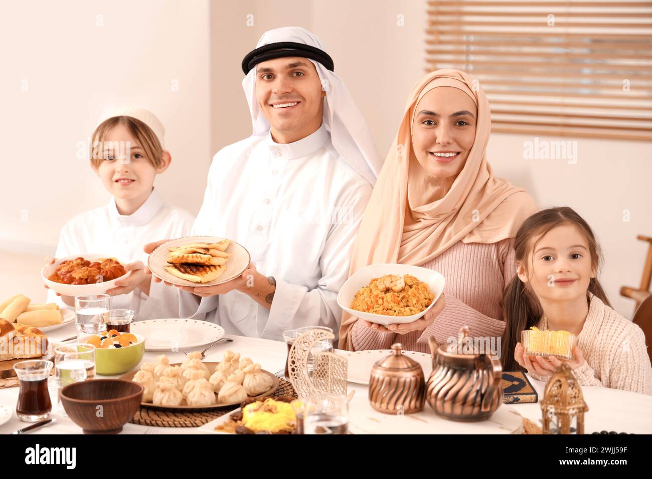 Happy Muslim family with traditional food having dinner at home ...