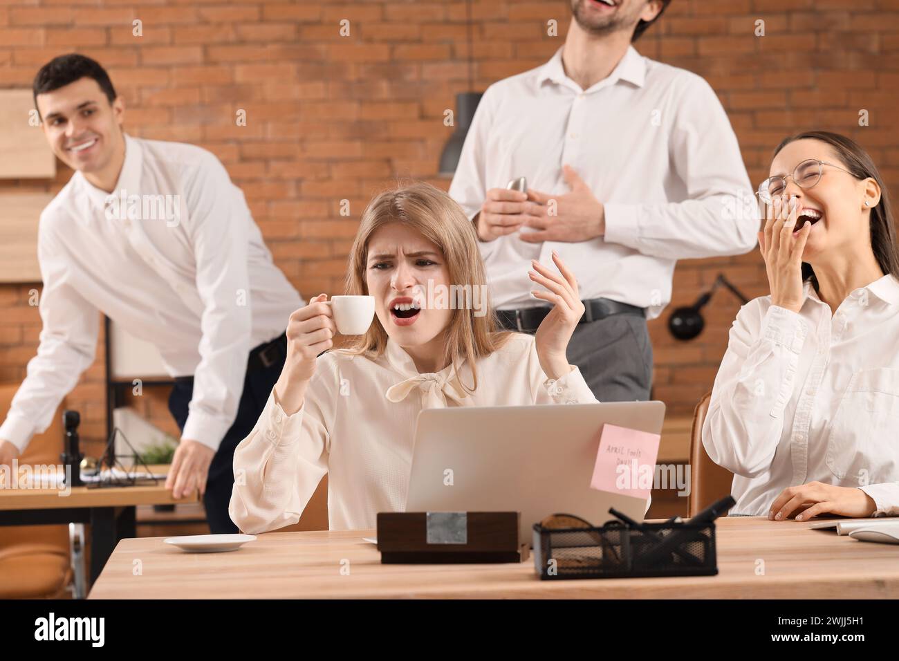 Angry young woman with salty coffee and her laughing colleagues in ...