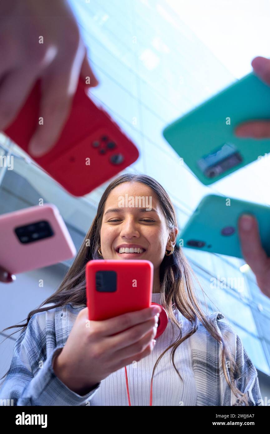 Group young people in circle using phones together outdoor. Cheerful ...