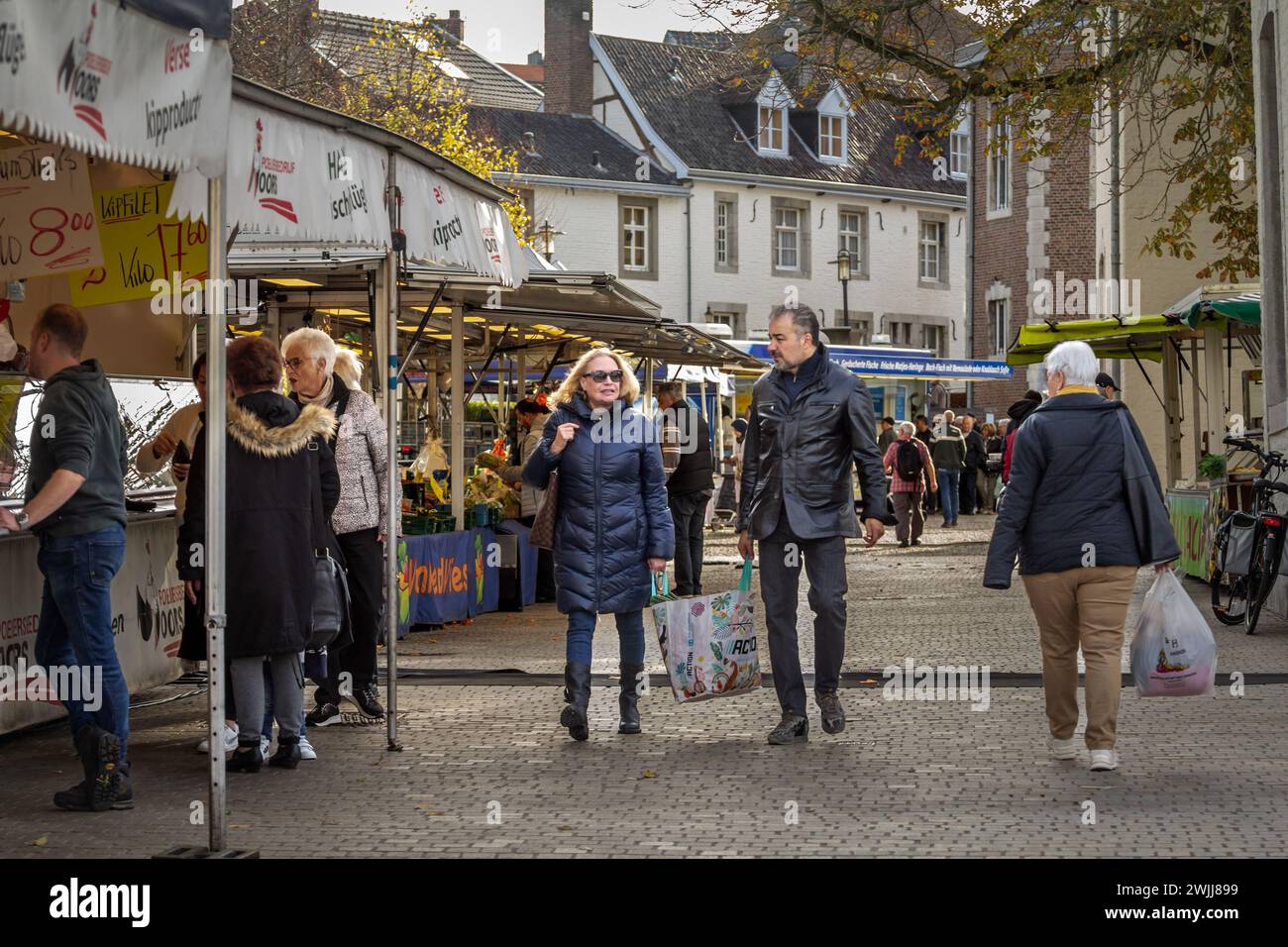 Picture of stalls of Vaals Farmers market iwith crowd of people passing ...