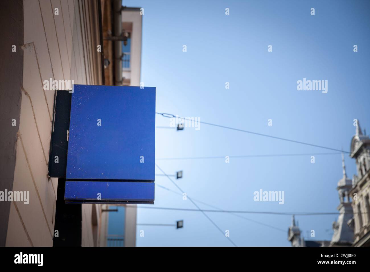 An empty, vibrant cobalt blue square signboard, prominently displayed ...