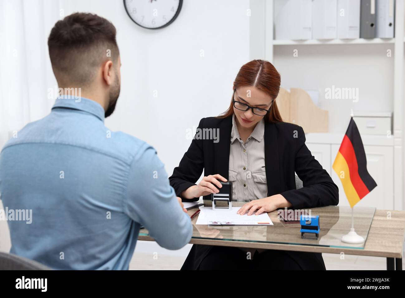 Immigration to Germany. Embassy worker approving visa application form ...
