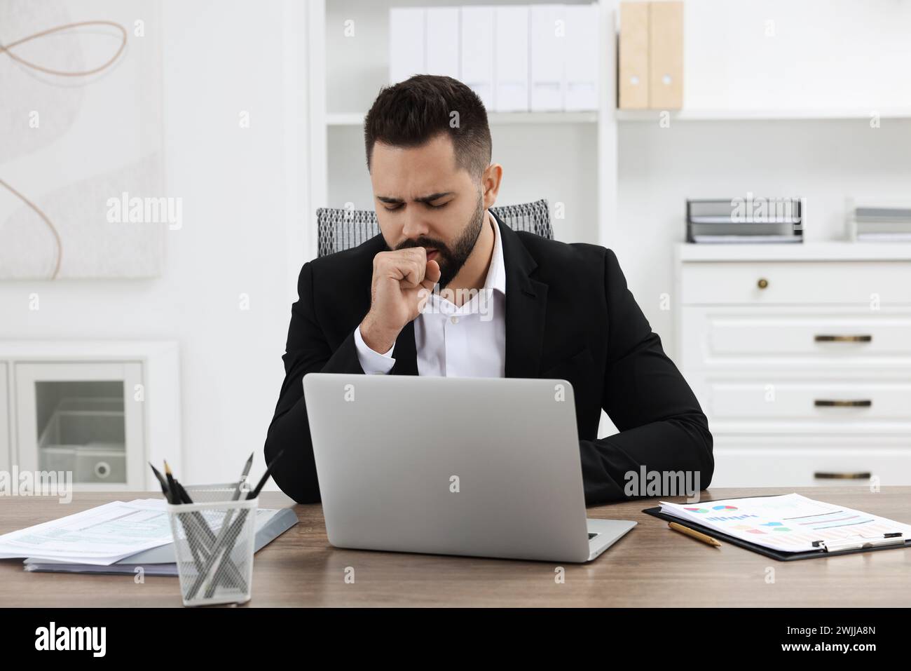 Sick man coughing at workplace in office Stock Photo - Alamy