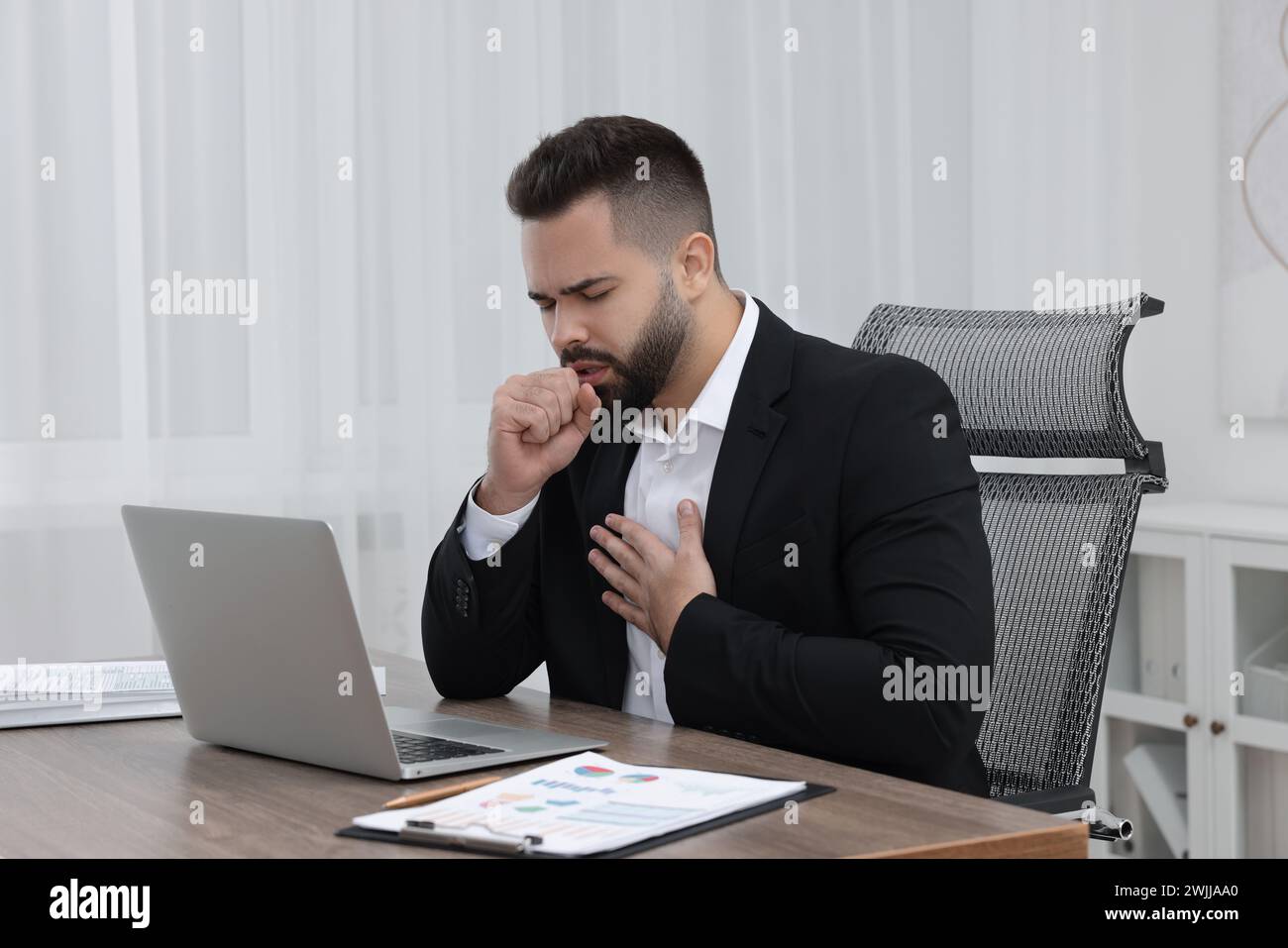 Sick man coughing at workplace in office Stock Photo - Alamy