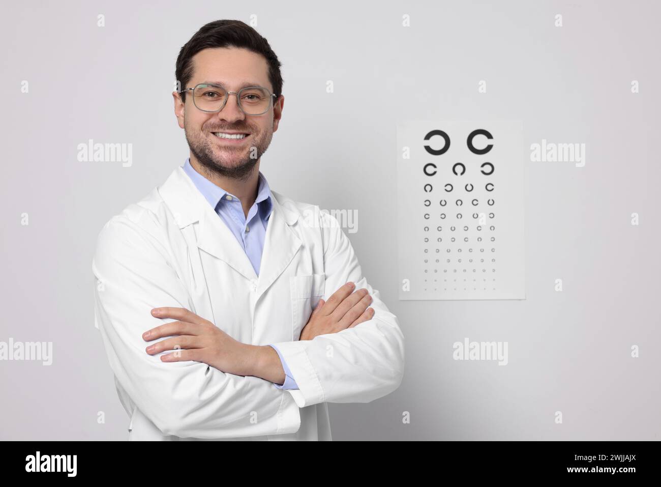 Ophthalmologist near vision test chart on white wall Stock Photo - Alamy