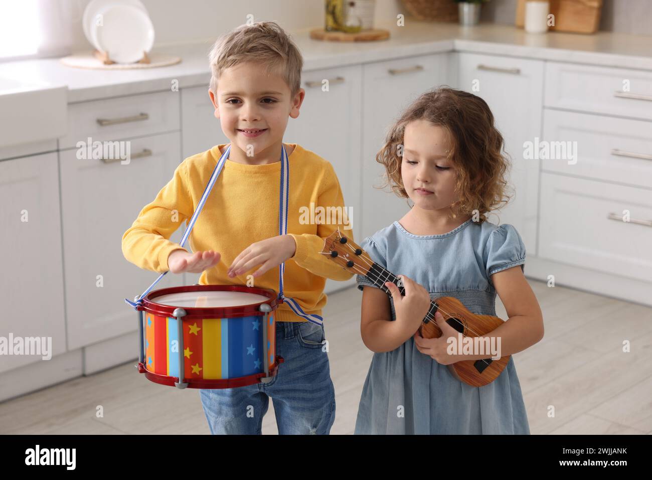 Little children playing toy musical instruments in kitchen Stock Photo ...