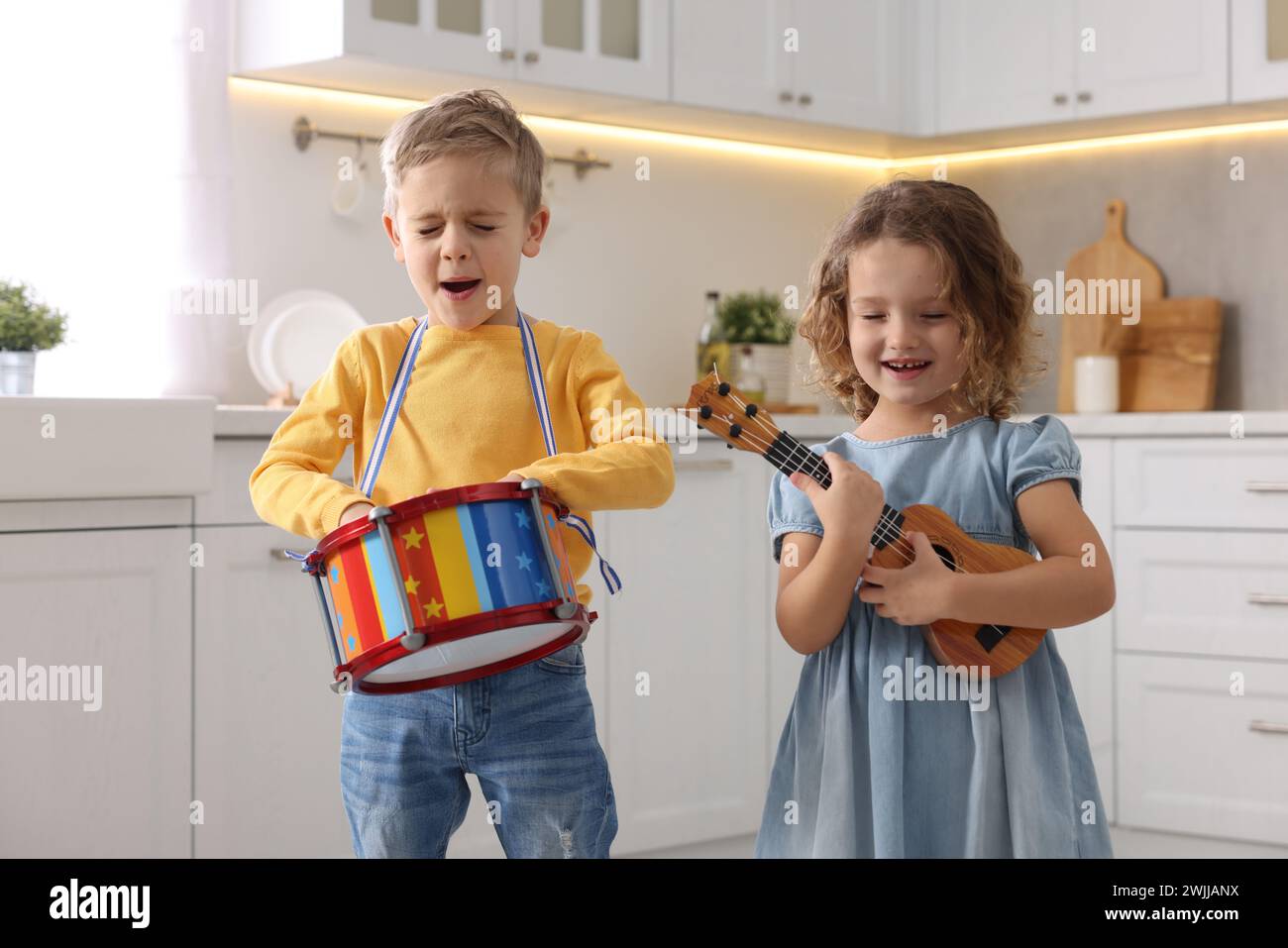 Little children playing toy musical instruments in kitchen Stock Photo ...