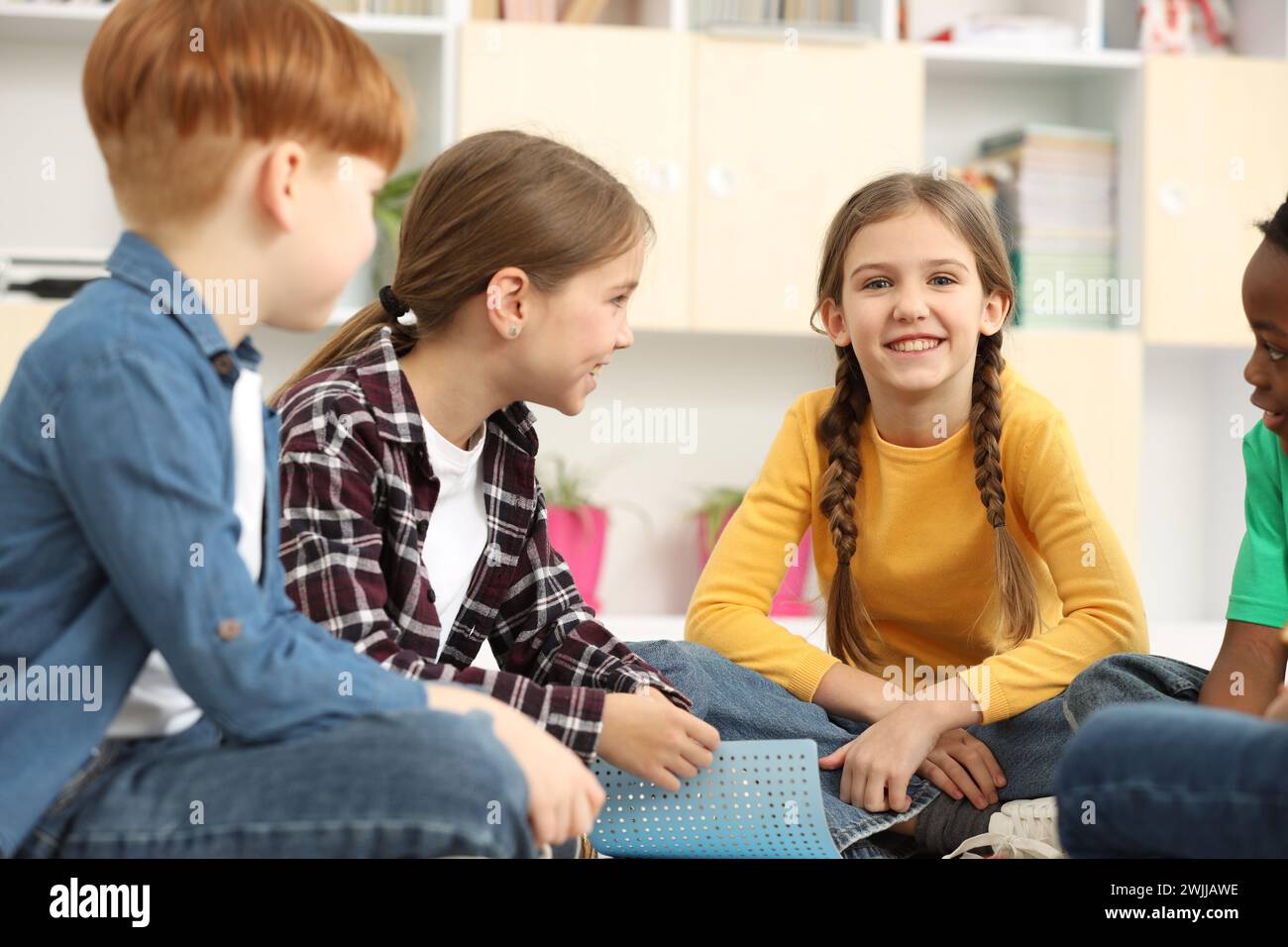 Cute children discussing in classroom at school Stock Photo - Alamy