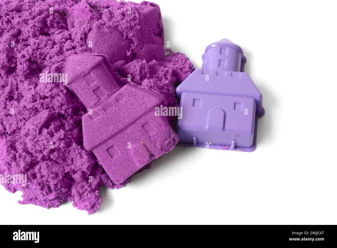 Castle made of purple kinetic sand and plastic mold on white background ...