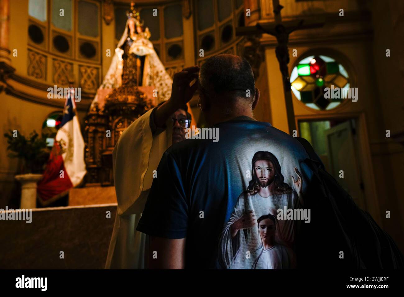 A priest marks a person's forehead with a cross of ashes during Ash ...