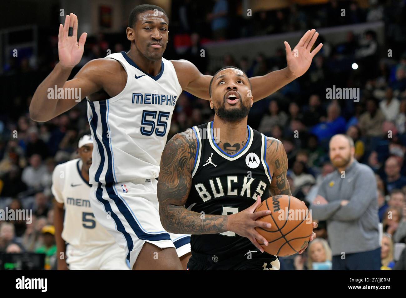 Milwaukee Bucks guard Damian Lillard, right, handles the ball ahead of ...