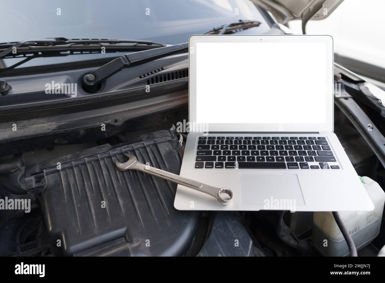 A blank screen laptop computer and wrench tool placing inside car's ...