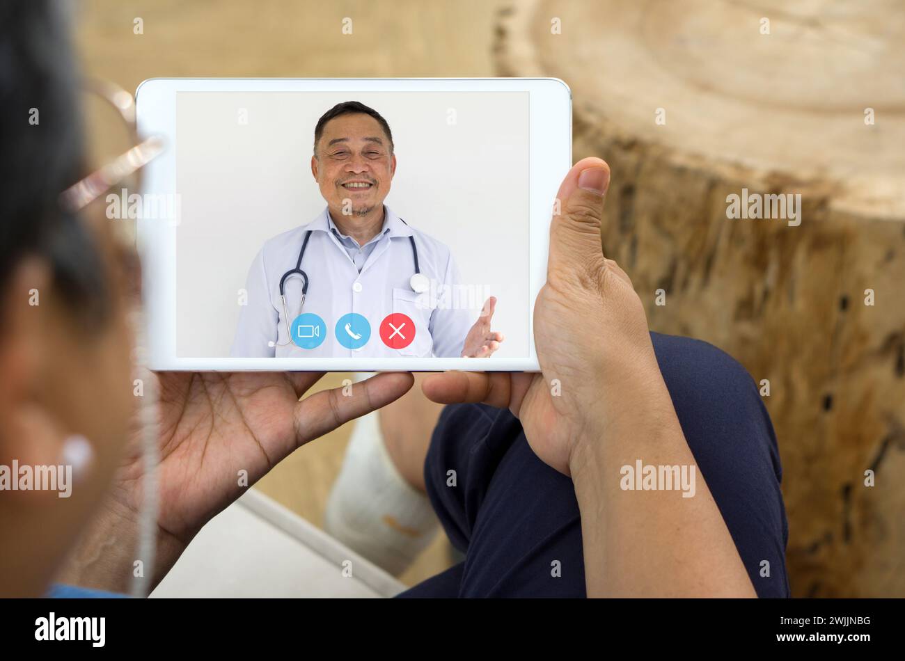 Back view of senior woman Telehealth consultation on the tablet ...