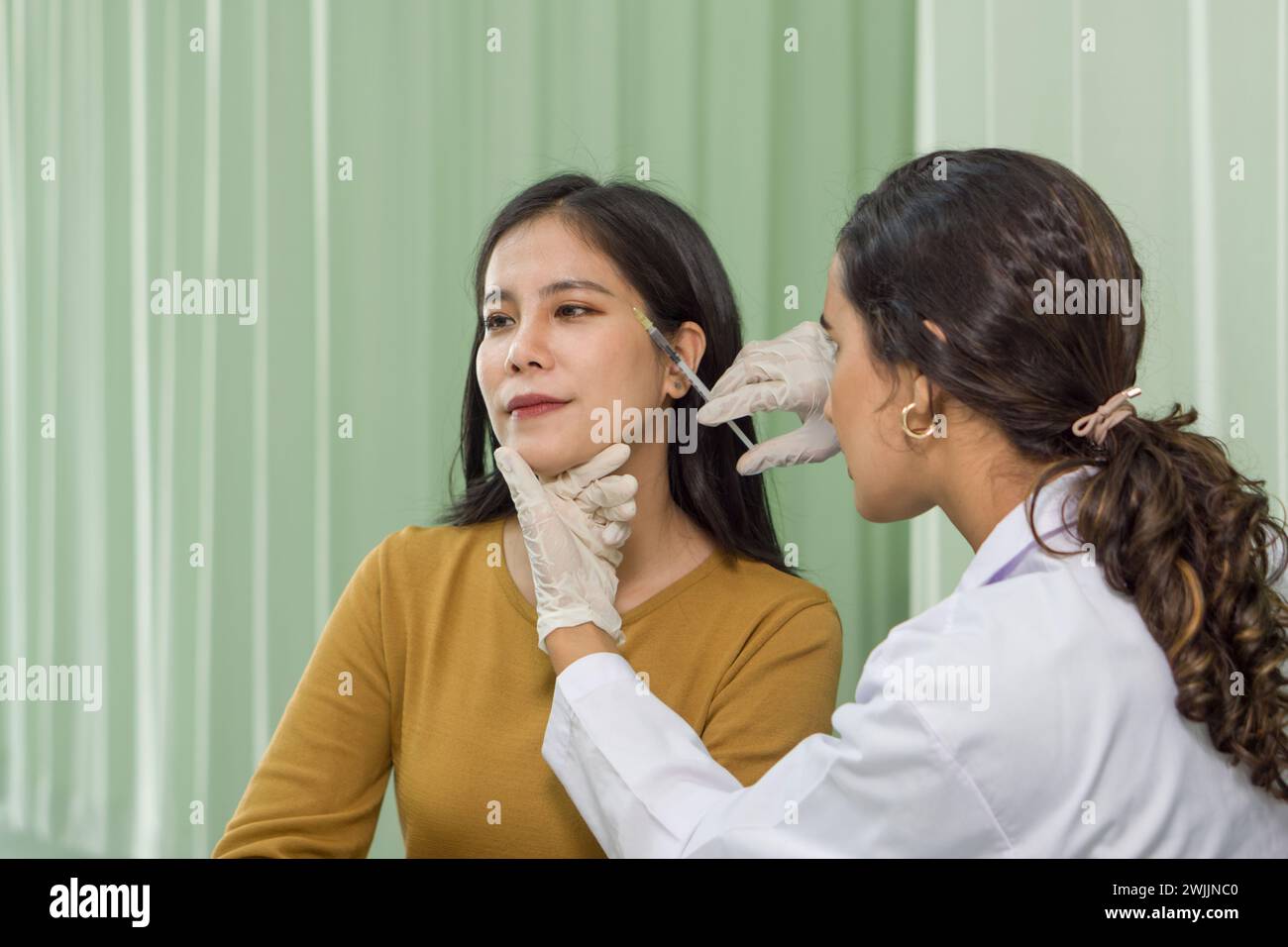 Doctor giving female patient medical injection in temporal. Atmosphere ...