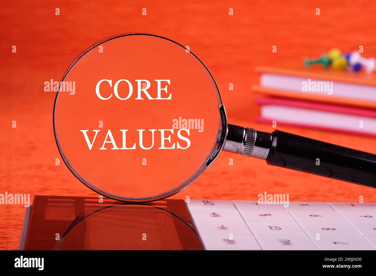 CORE VALUES word written through a magnifying glass on an orange ...