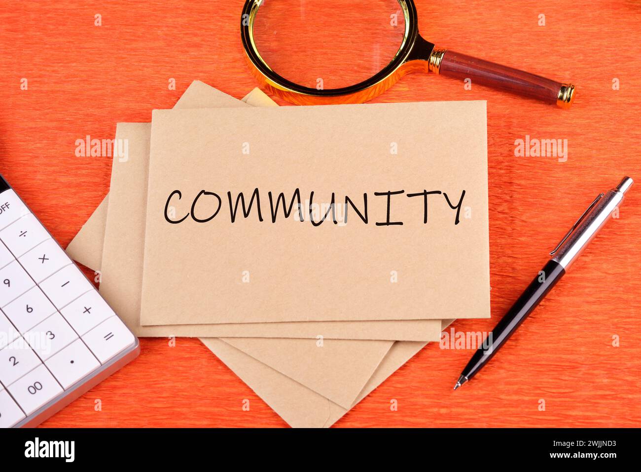 The word Community written on the envelope next to a magnifying glass ...
