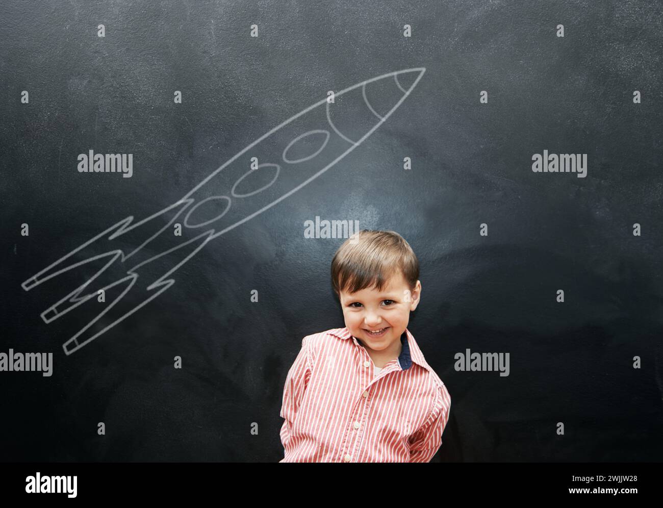 Child, boy and portrait or happy by blackboard with drawing, missile ...