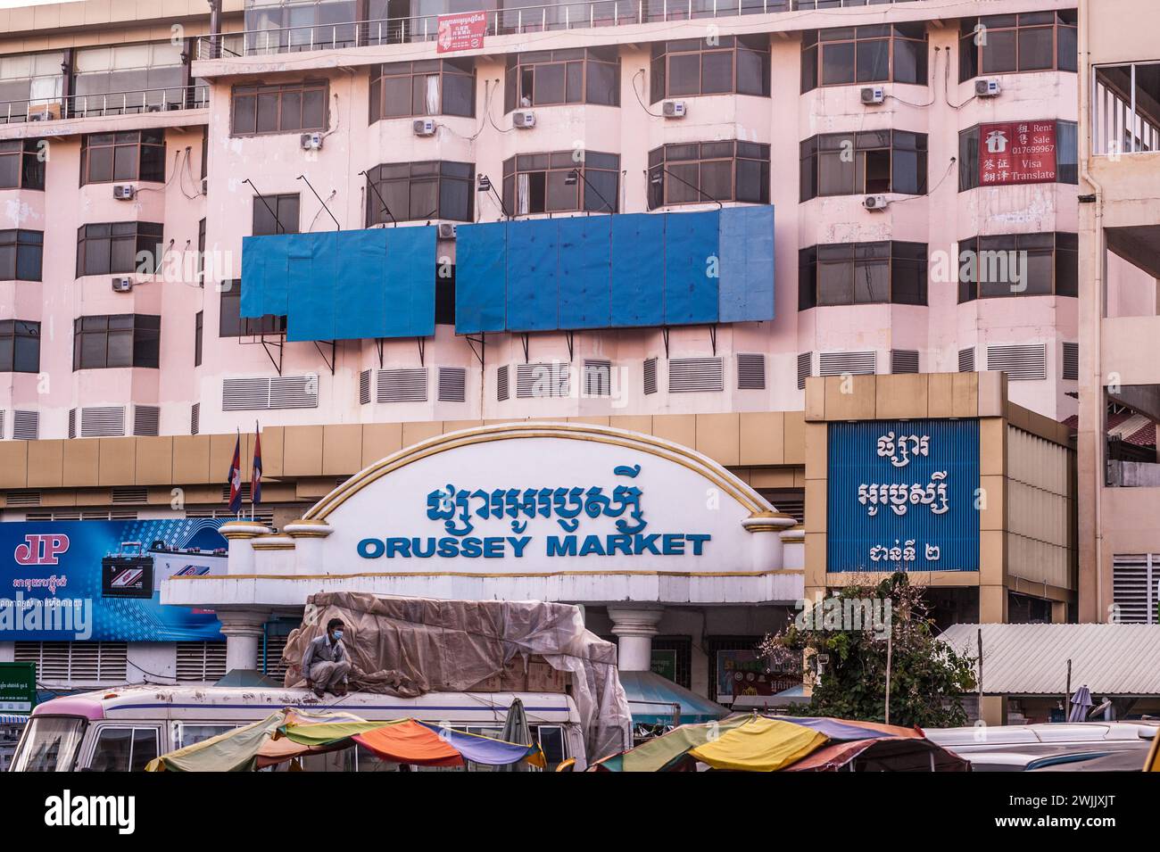 The bilingual sign at the entrance to Orussey Market. A Cambodian man ...