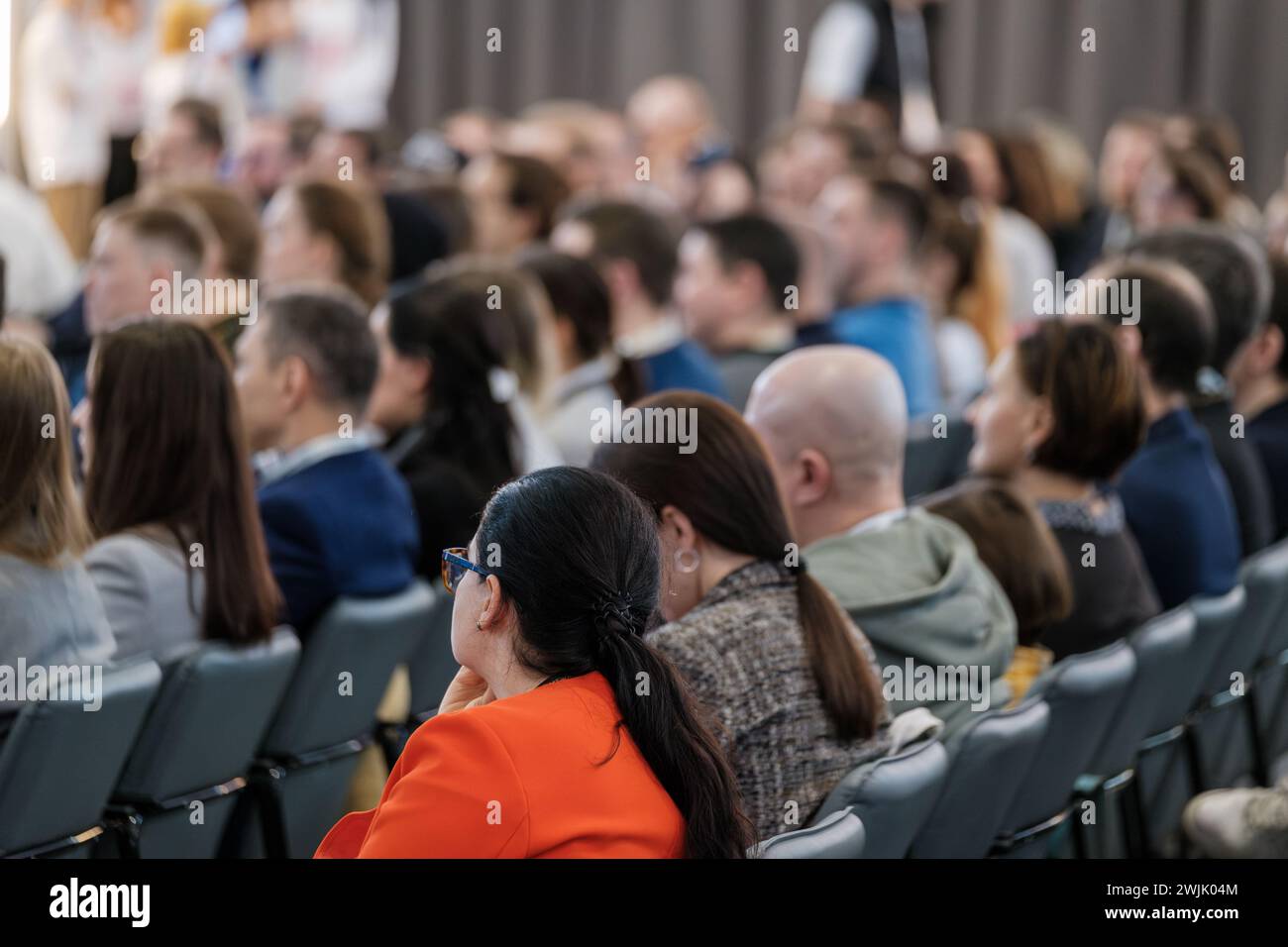 Focused audience members at a conference, engaging with the speaker in ...