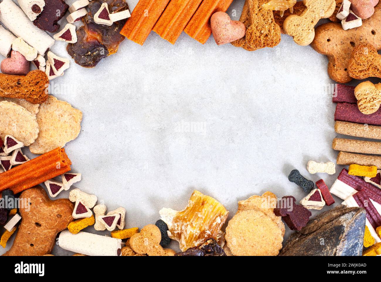 Frame of dog treats and chews with copy space. Flat lay on mottled grey ...