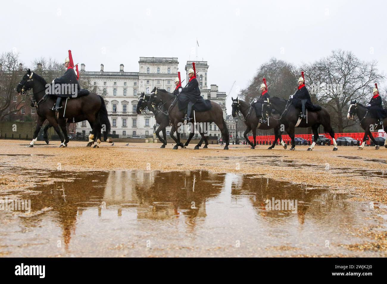 Members of the Household Cavalry Mounted Regiment reflect in rain water ...