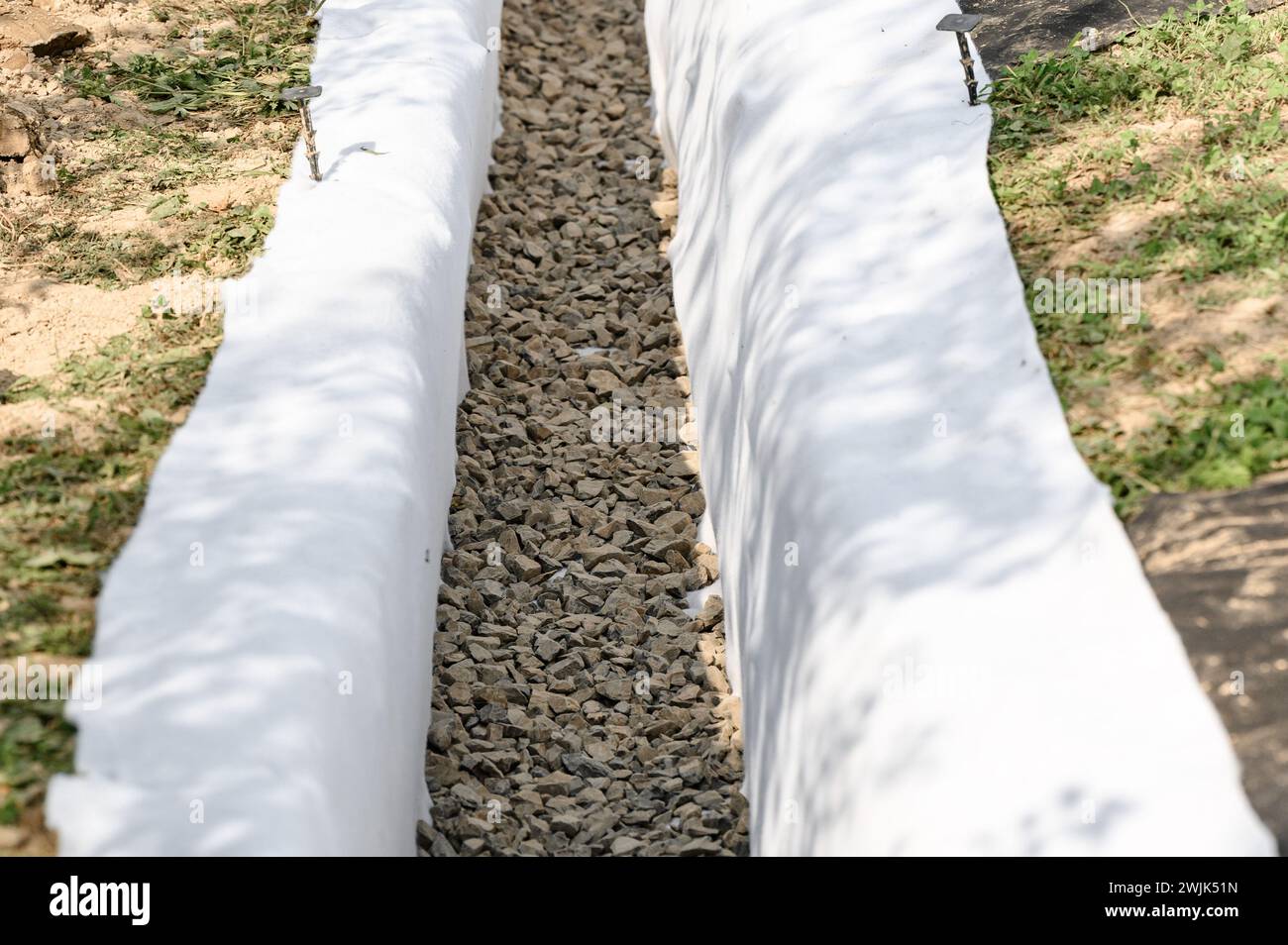 The drainage trench is covered with geotextile and filled with crushed ...