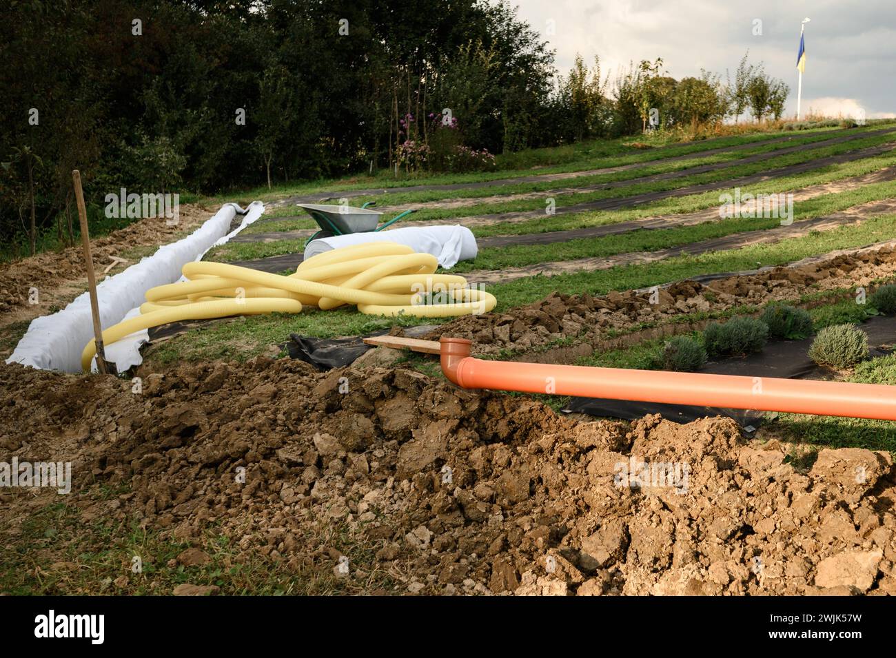 Yellow corrugated pipe with perforation in a trench with crushed stone ...