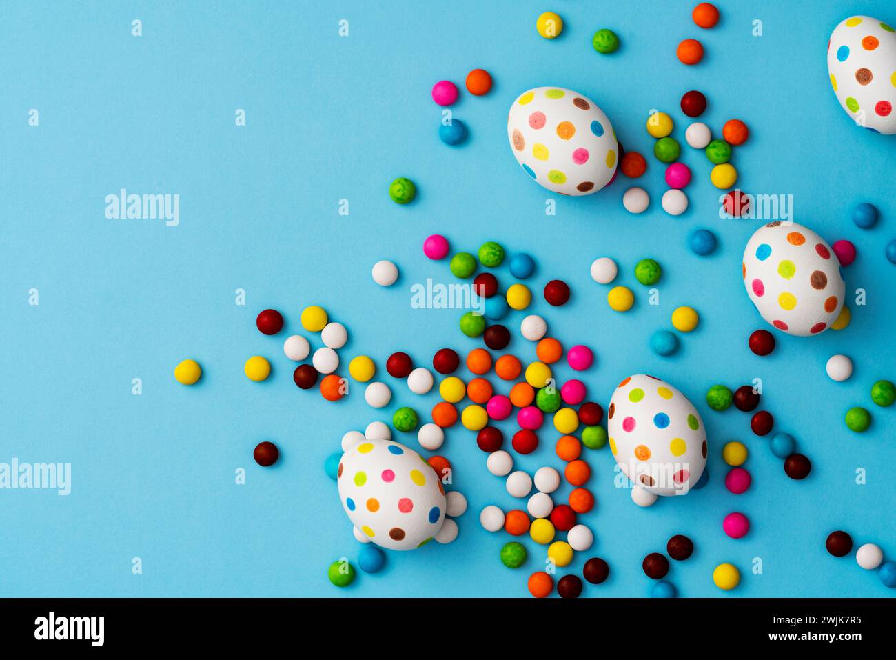Spotty painted colorful easter eggs and colourful chocolate candies on ...